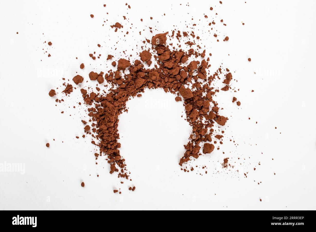 circle shaped cocoa powder spilled and scattered , close up on white ...