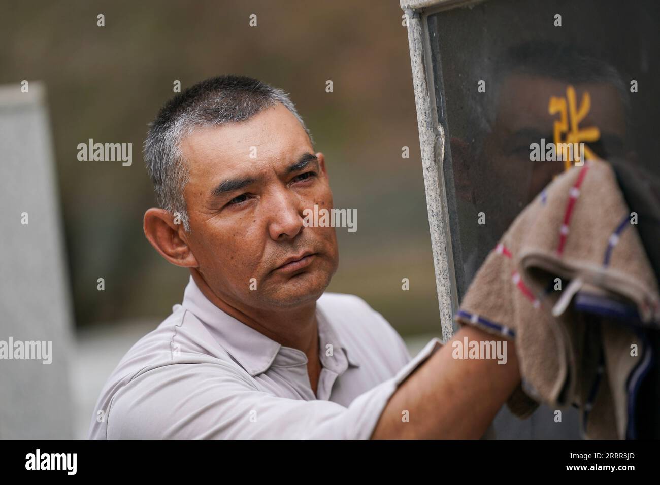 230430 -- YECHENG, April 30, 2023 -- Eniwar Emer wipes a tombstone in ...