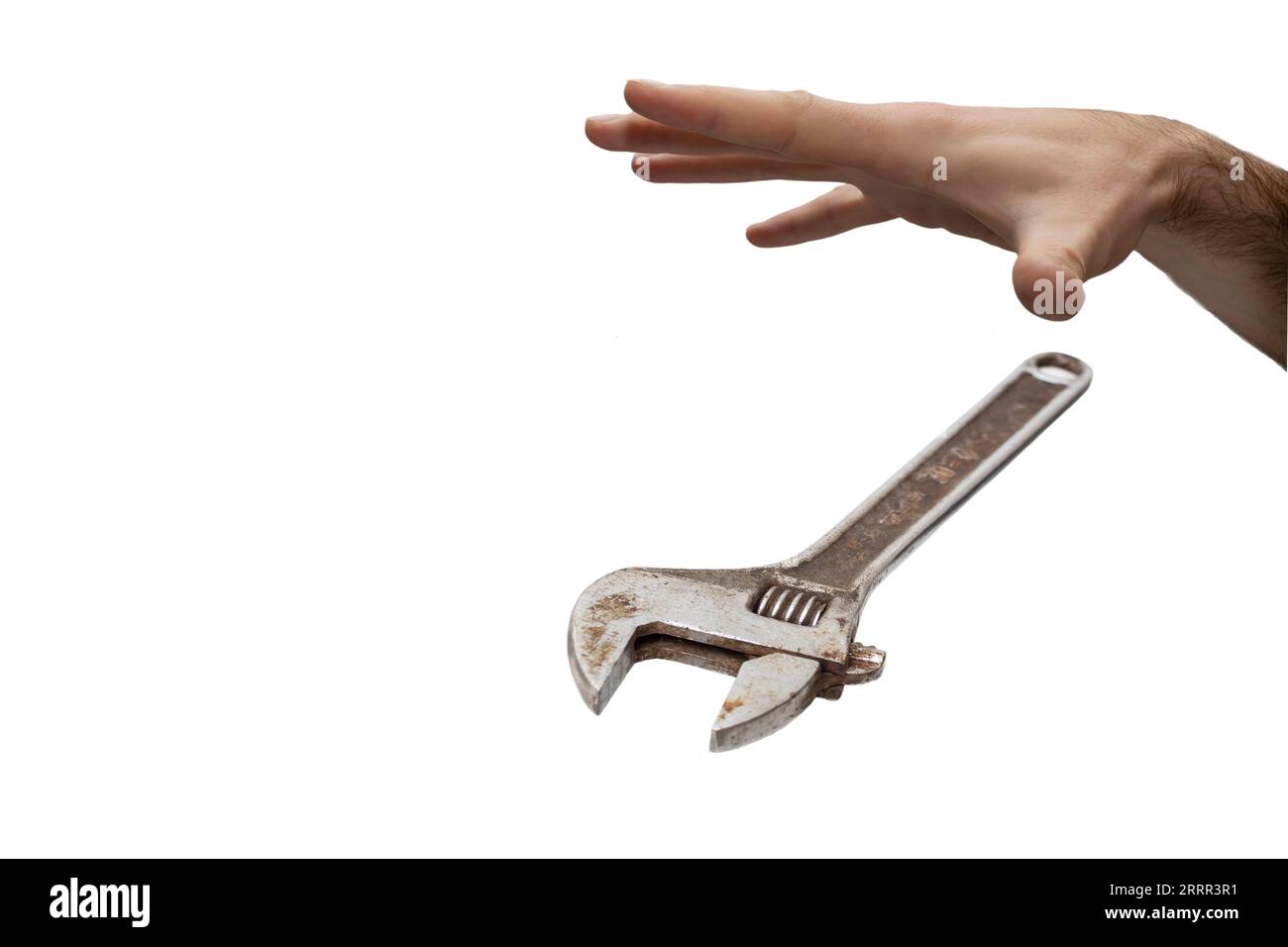 Male hand dropping an adjustable wrench, soft focus close up isolated ...