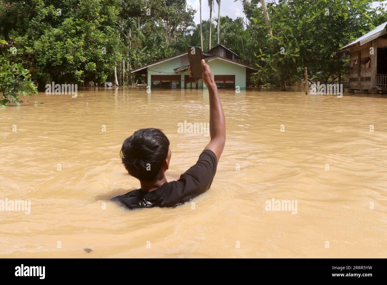 230507 -- ACEH BARAT, May 7, 2023 -- A man holds his cell phone to ...