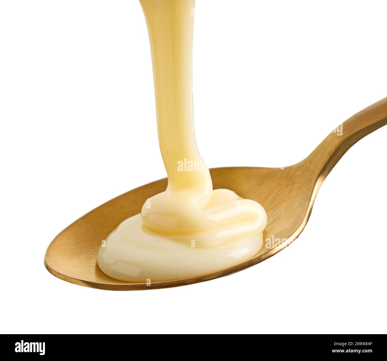 condensed milk in golden spoon isolated on white background Stock Photo ...