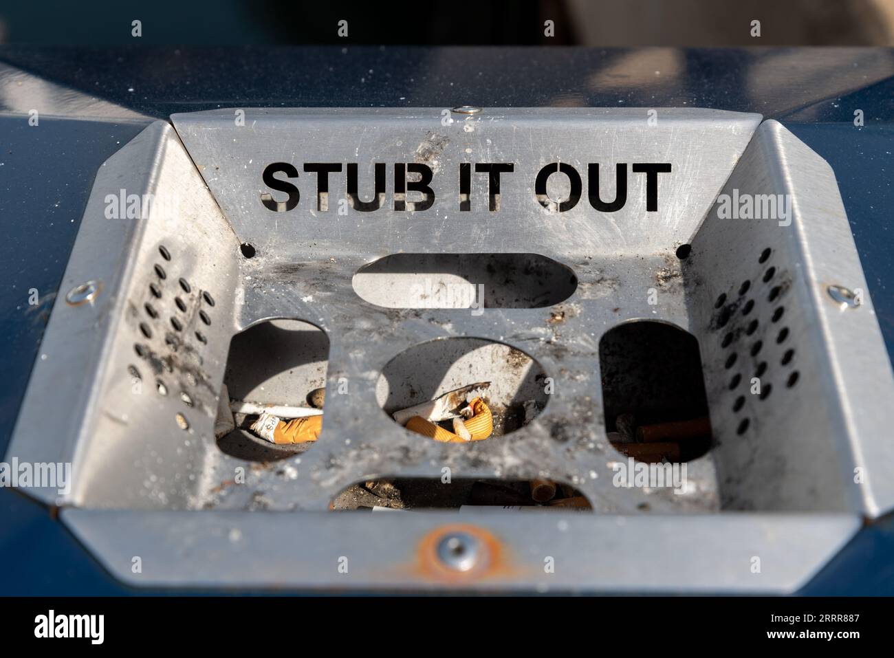 Stub it out cigarette ashtray in a shopping centre, showing ash and ...