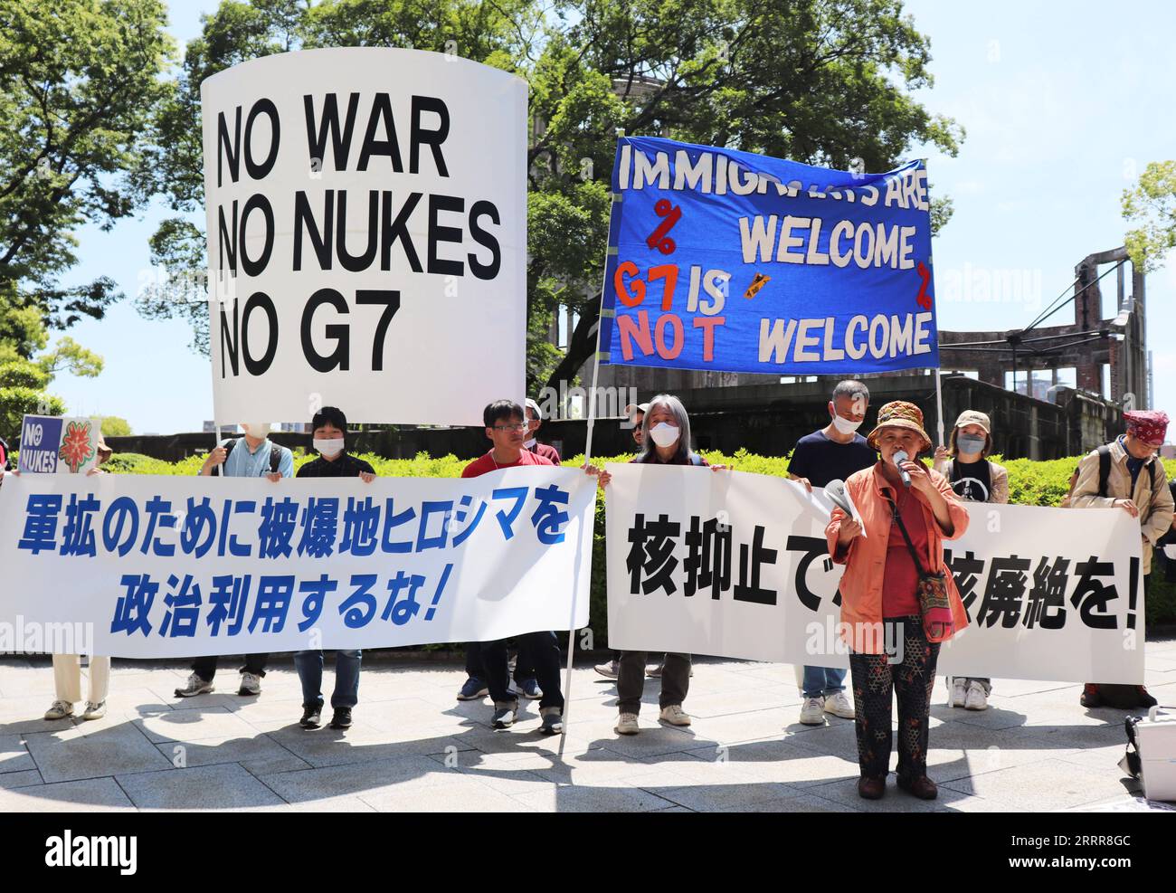 230515 -- HIROSHIMA, May 15, 2023 -- People holding banners protest ...