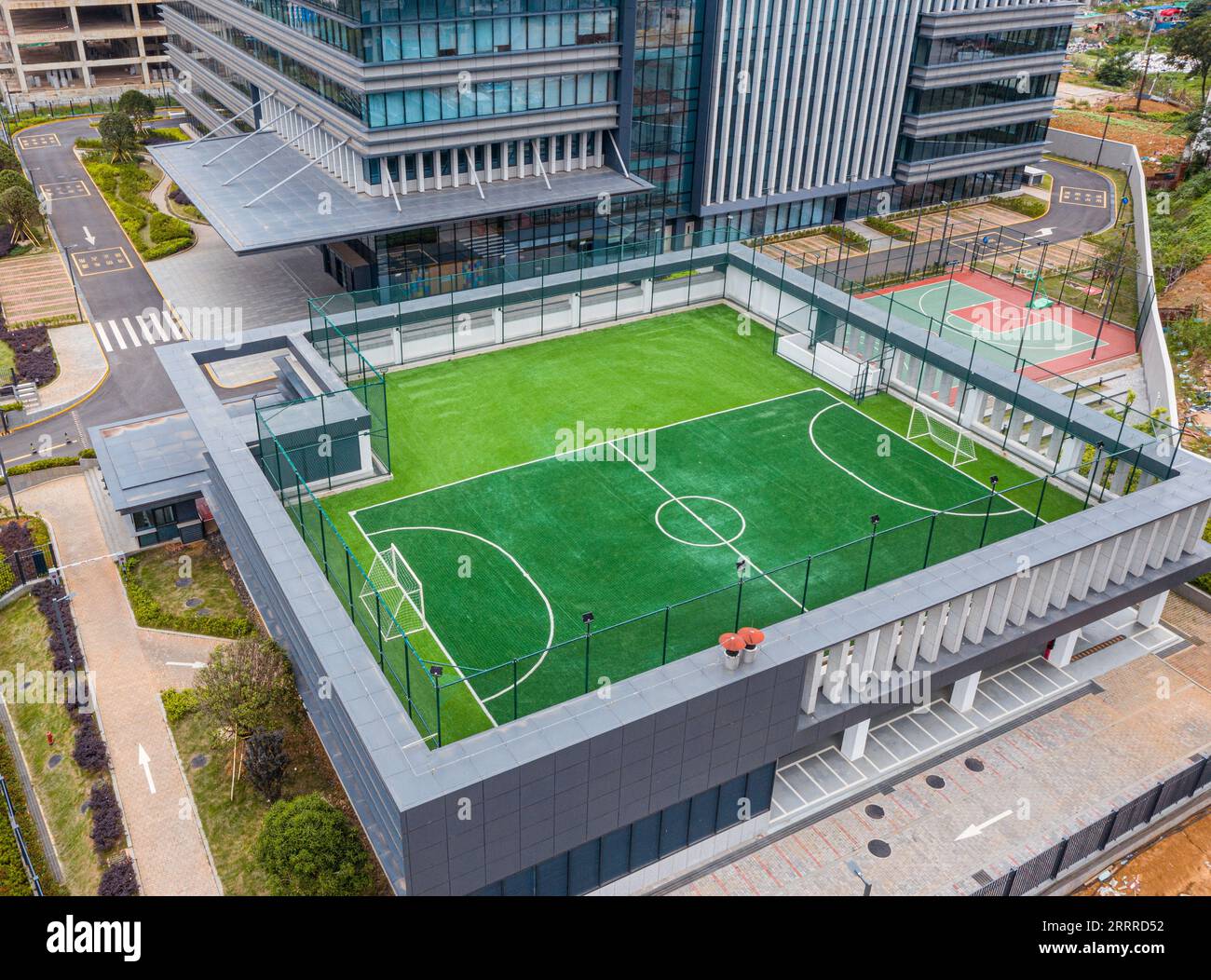 An aerial view of a rooftop sports ground next to a high-tech company ...