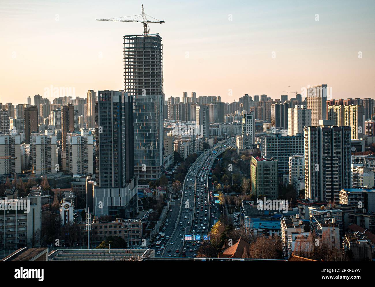 A modern high-rise building towering over a bustling city skyline in ...