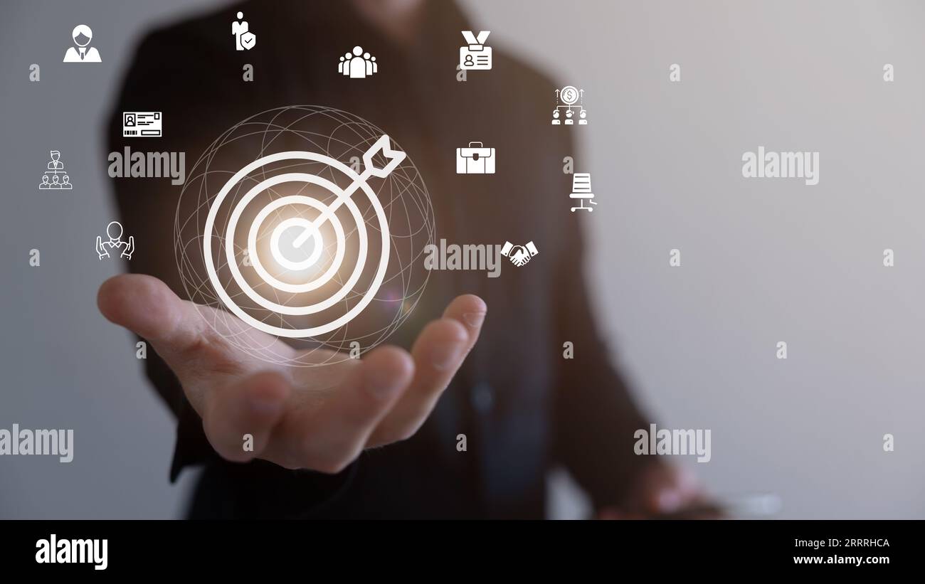 Businessman hand and arrow icon hitting center of dartboard target ...