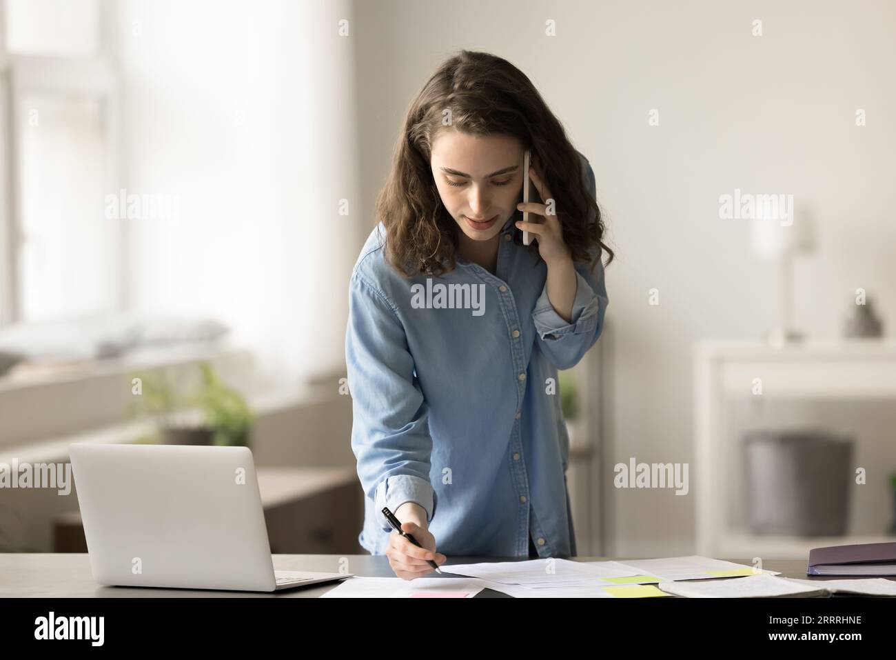 Busy young gen Z business woman talking on mobile phone Stock Photo - Alamy