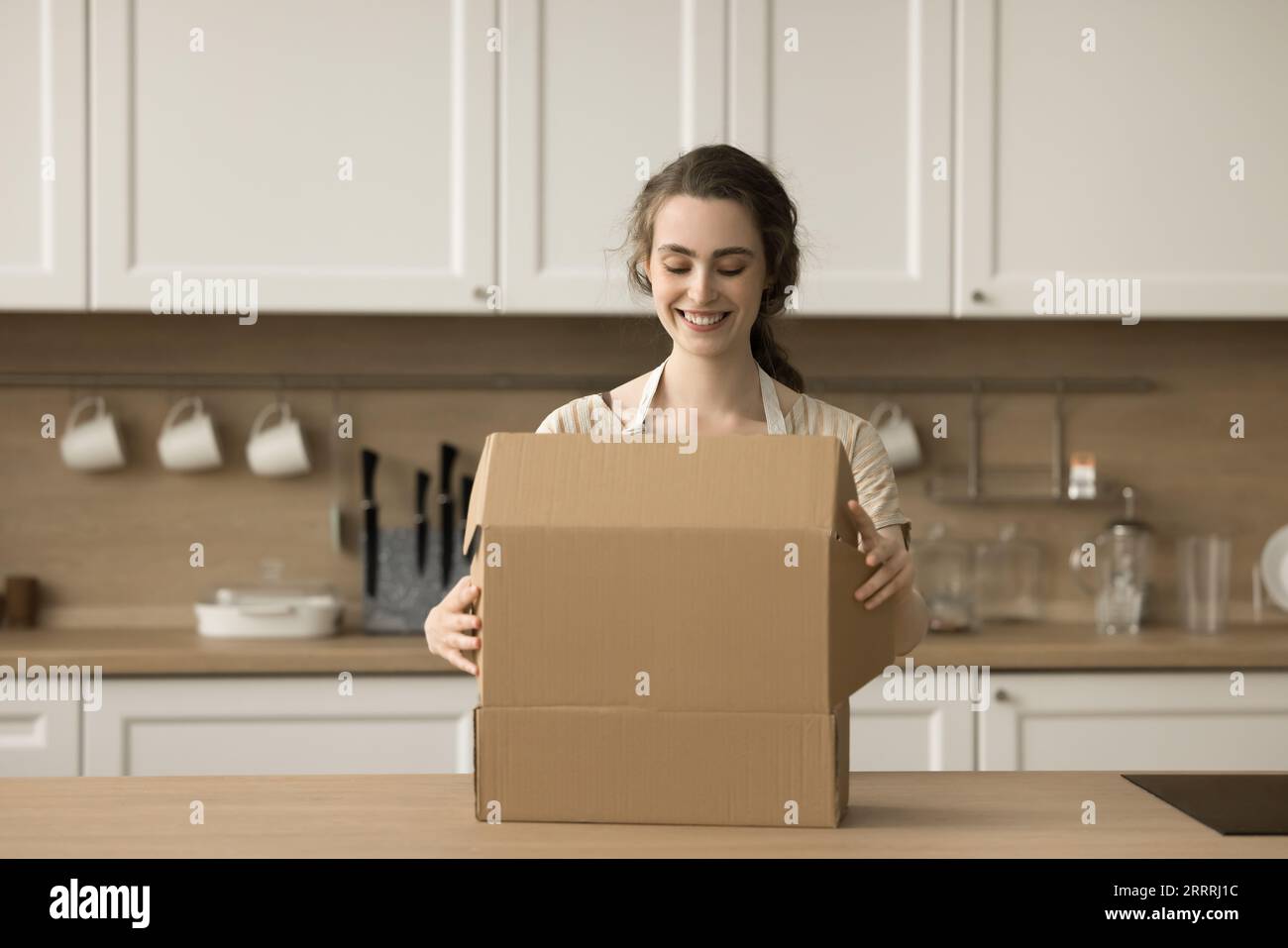Happy beautiful young customer woman opening package Stock Photo - Alamy
