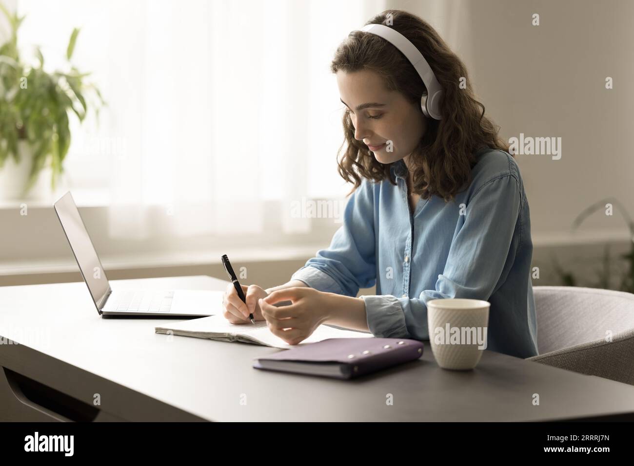 Modern gen Z student girl in earphones studying on Internet Stock Photo ...