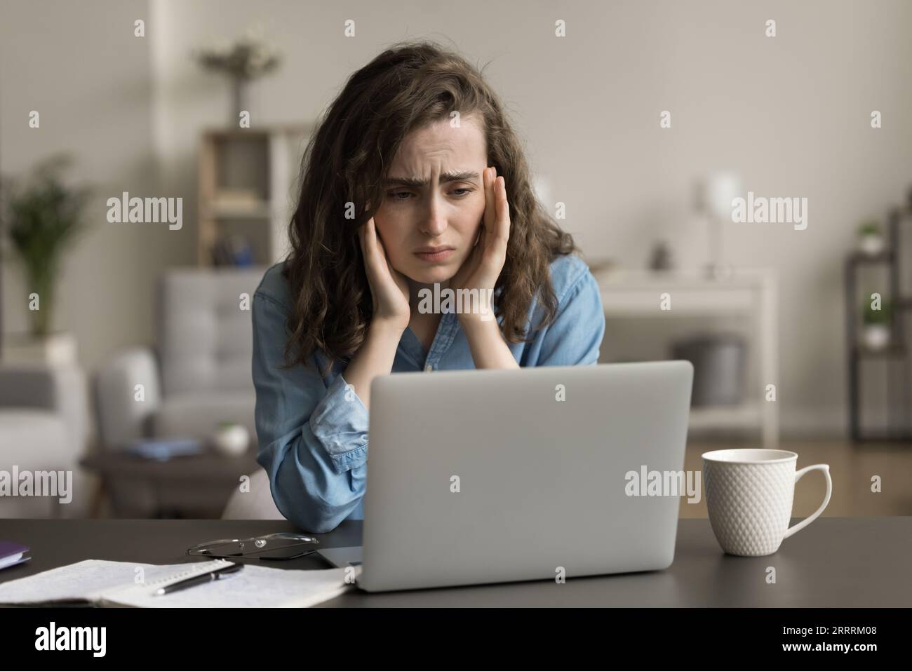Sad gen Z freelancer girl suffering from headache at workplace Stock ...
