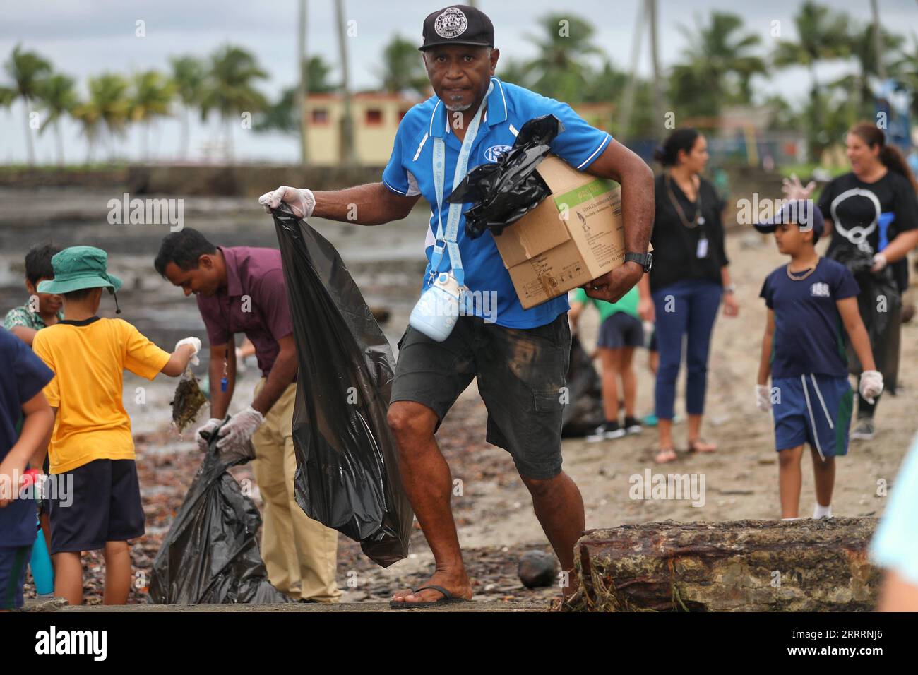 230607 -- SUVA, June 7, 2023 -- Students and teachers collect trash at ...