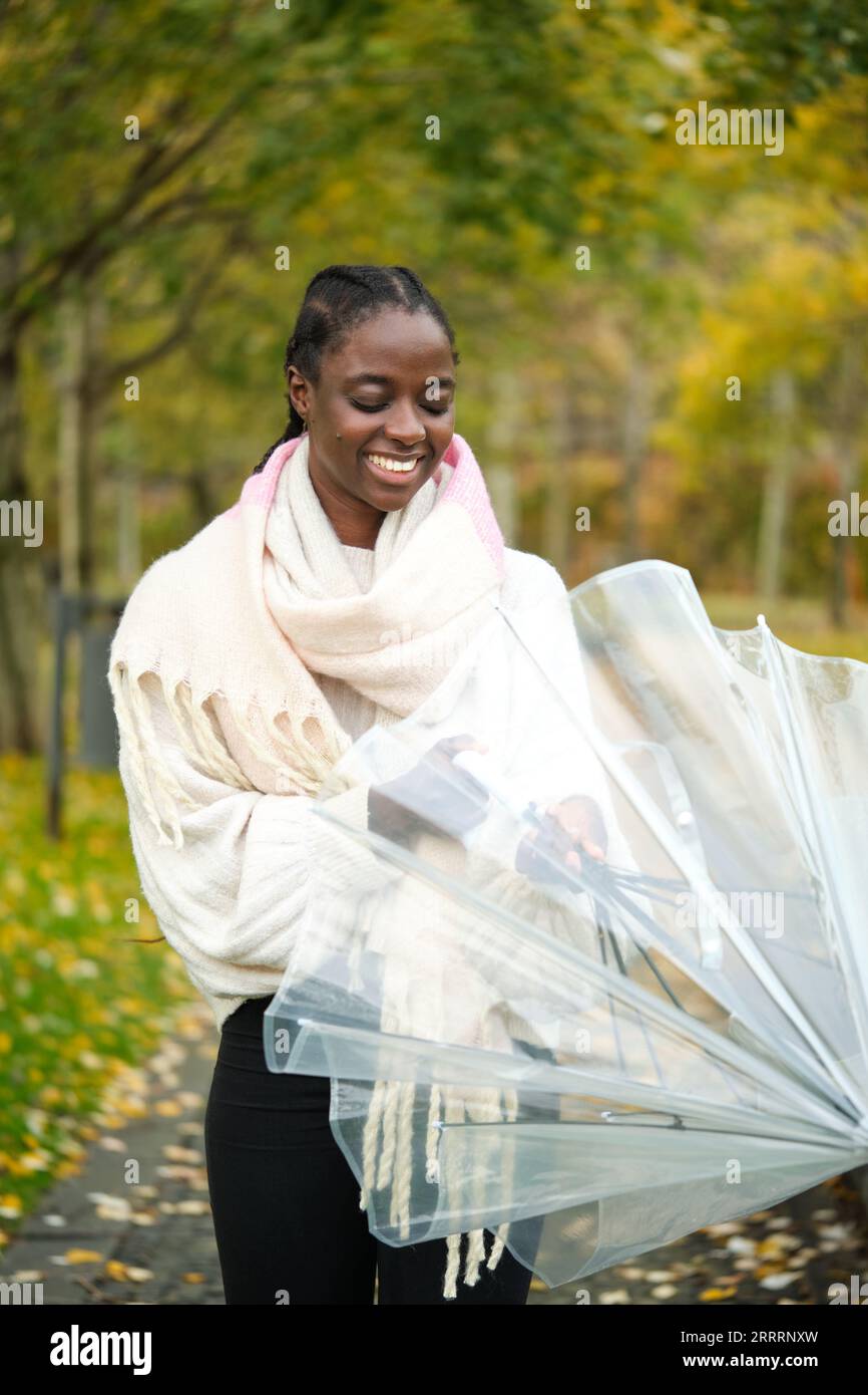 African woman closing the umbrella in autumn Stock Photo - Alamy