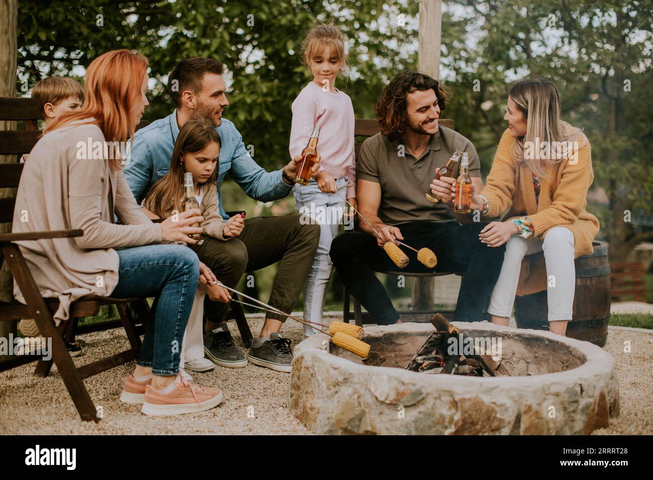 Group of friends having good time and baking corns in the house ...