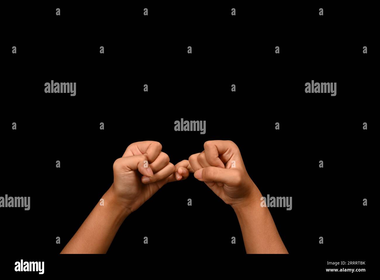 Two hands hooking each other little finger on black background, symbol ...