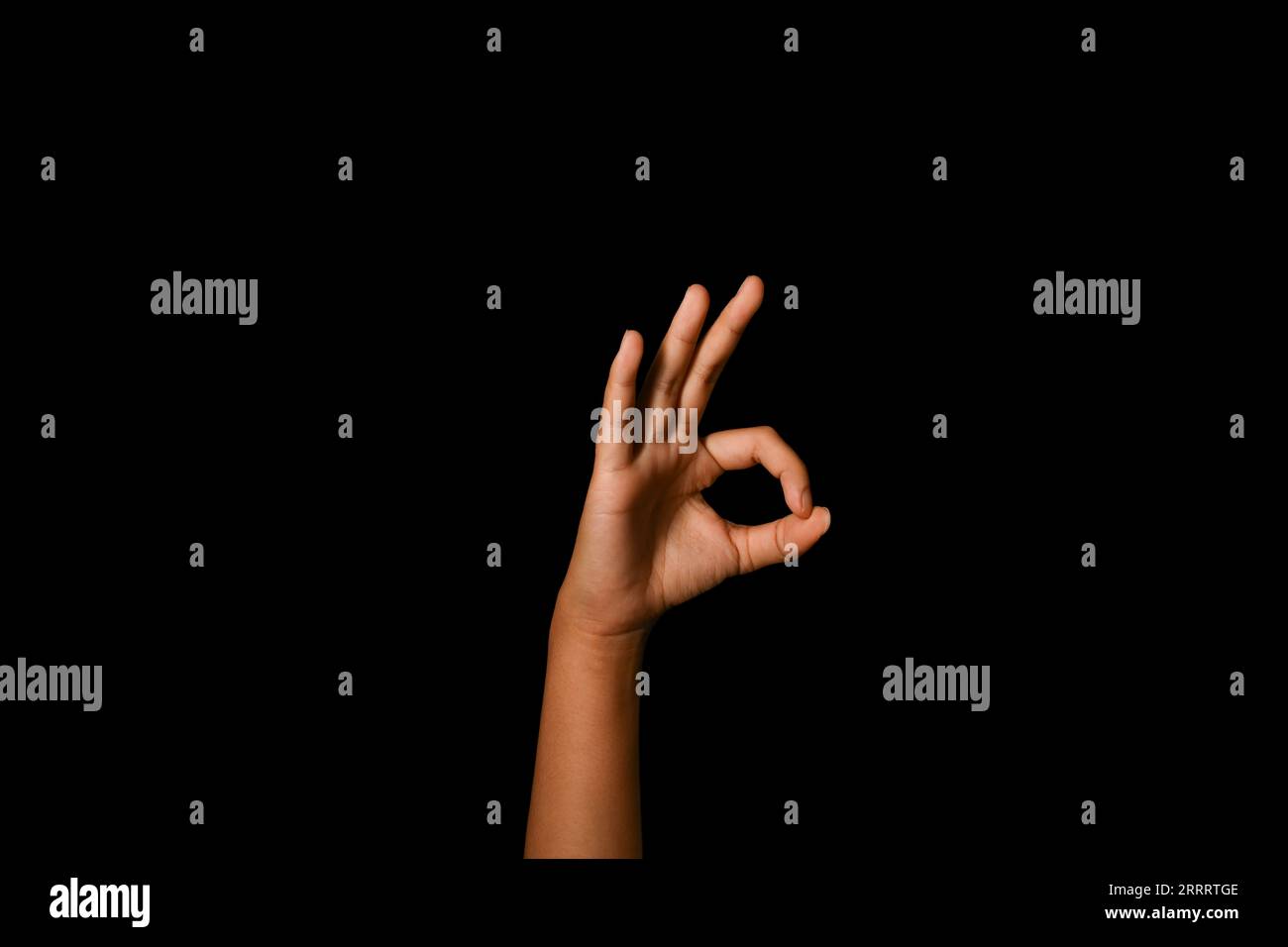 Hand making okay sign on black background, sign of approval and good ...