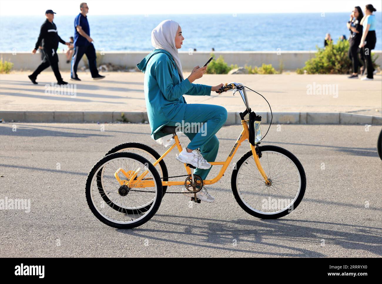 230619 -- BEIRUT, June 19, 2023 -- A woman enjoys riding a bike at the ...