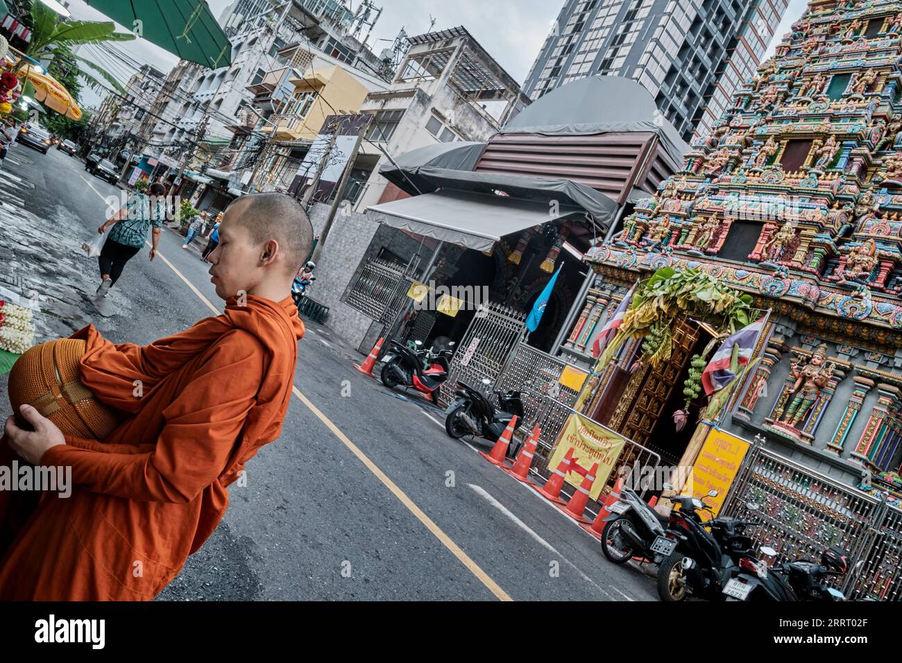 A Thai Buddhist monk on his daily morning alms round collecting alms ...