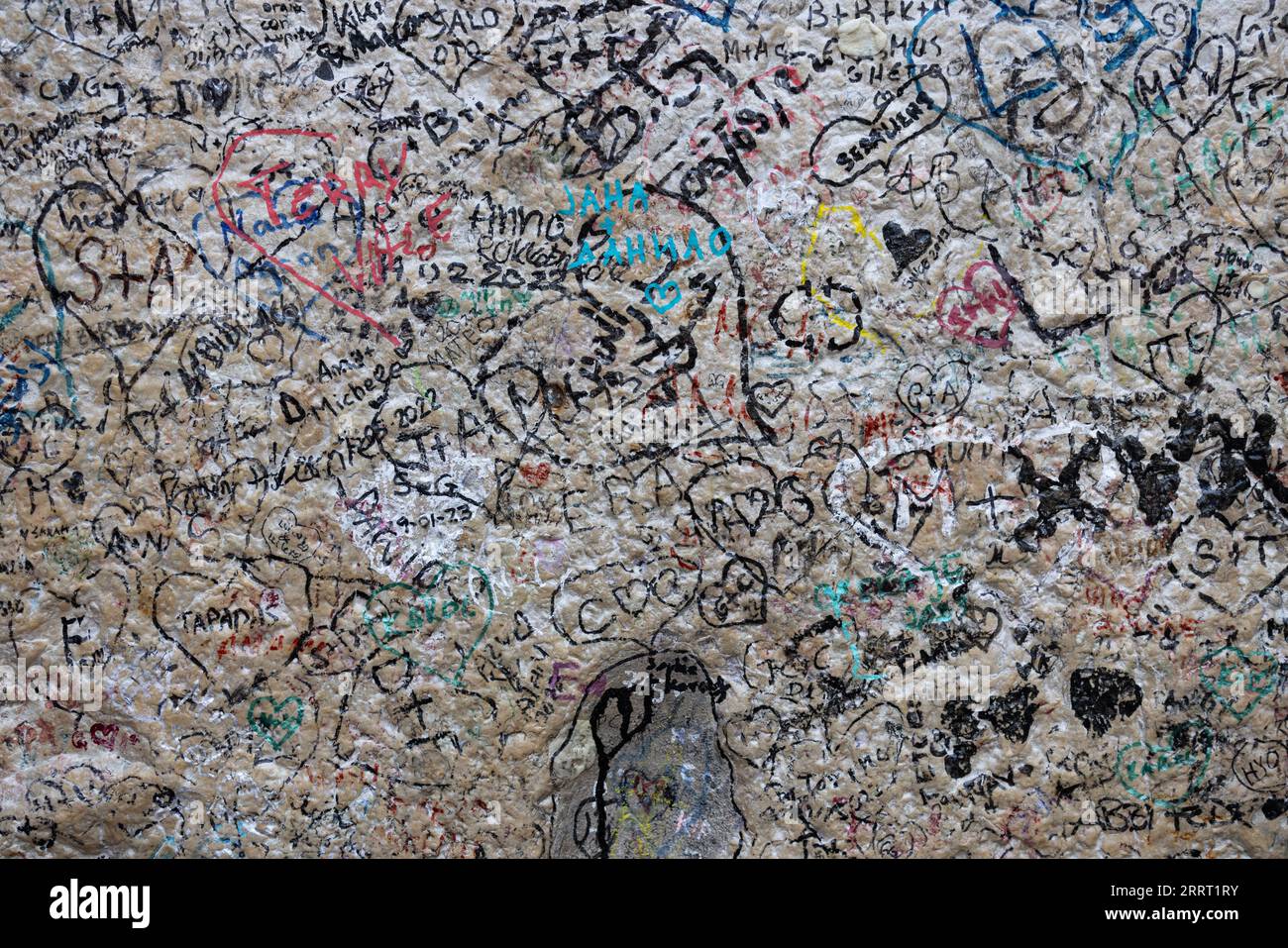 Wall covered with graffiti from visitors from all over the world. A ...