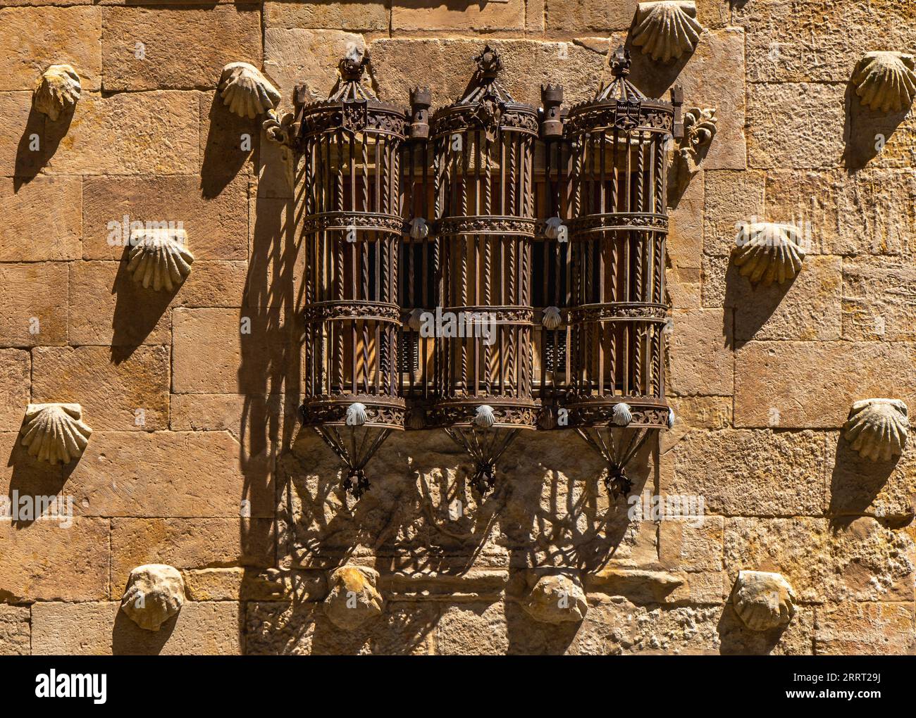 Old medieval wrought iron balcony divided into three cylindrical parts ...