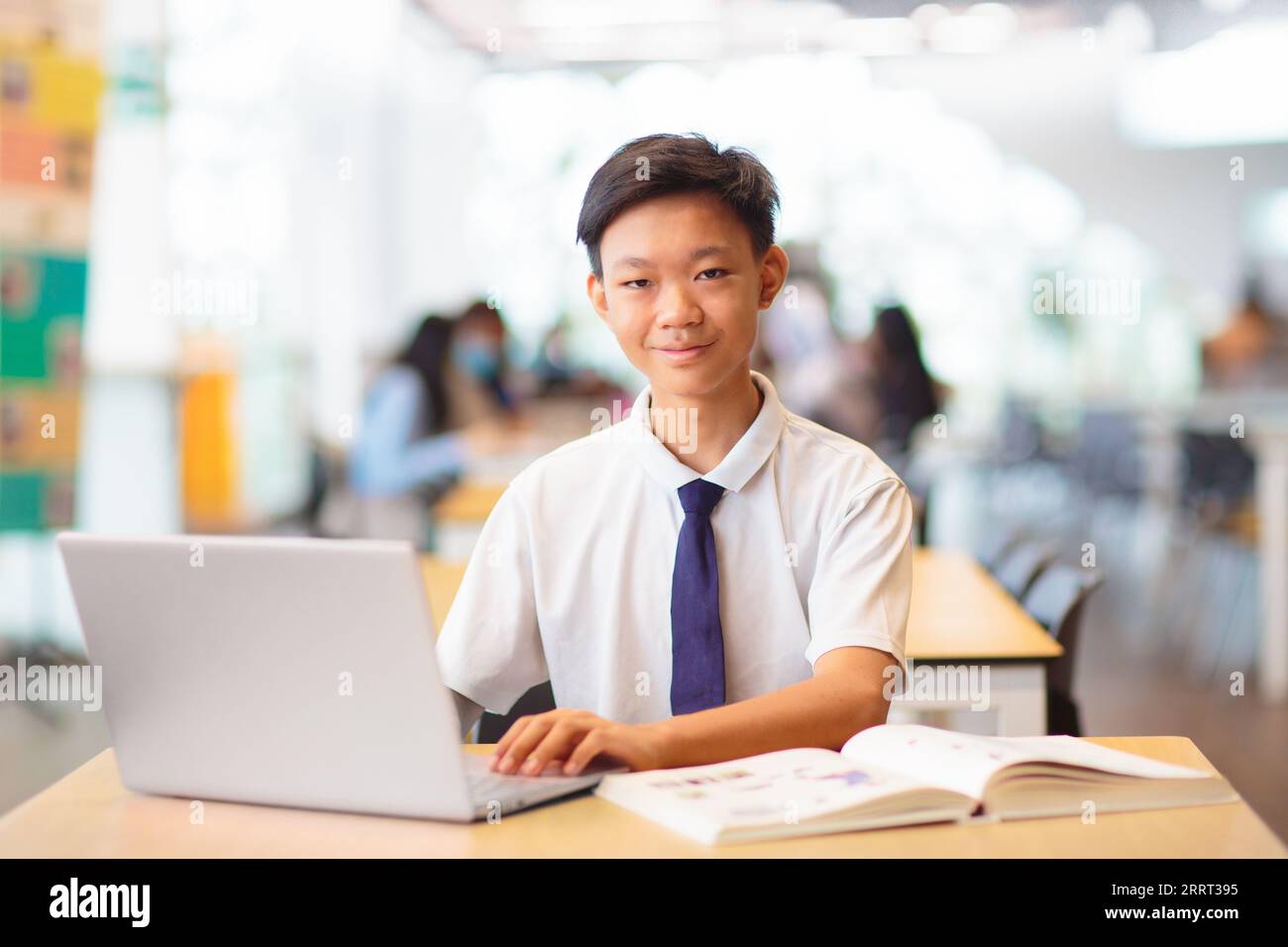 Asian boy with laptop in school. Student in classroom. Teenager in ...