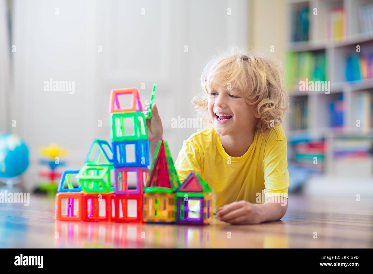Child playing with magnetic building blocks. Little boy building tower ...