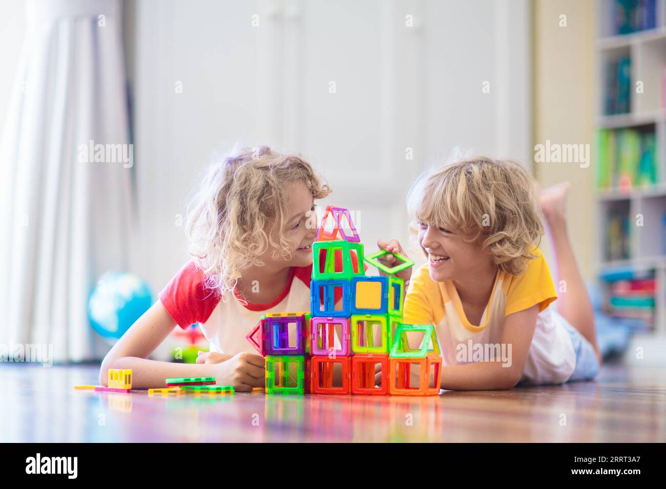 Child playing with magnetic building blocks. Little boy building tower ...