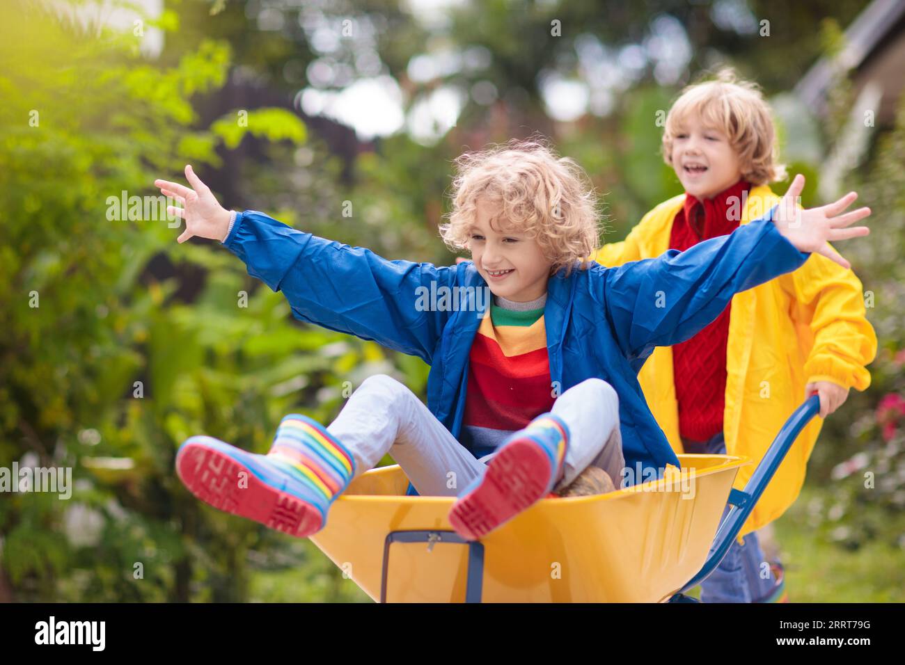 Kids in wheelbarrow on pumpkin patch. Autumn outdoor fun for children ...