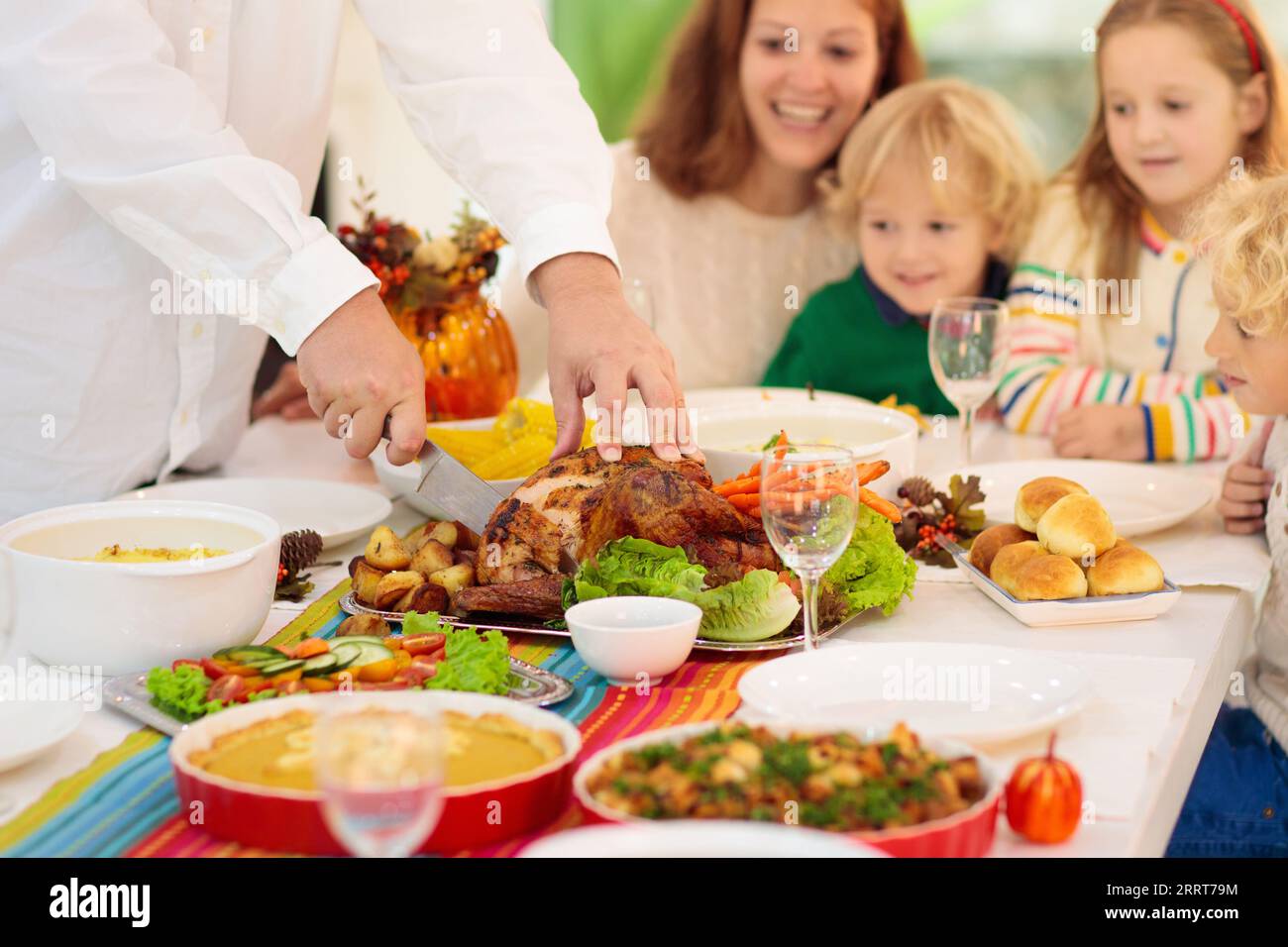 Family with kids eating Thanksgiving dinner. Roasted turkey and pumpkin ...