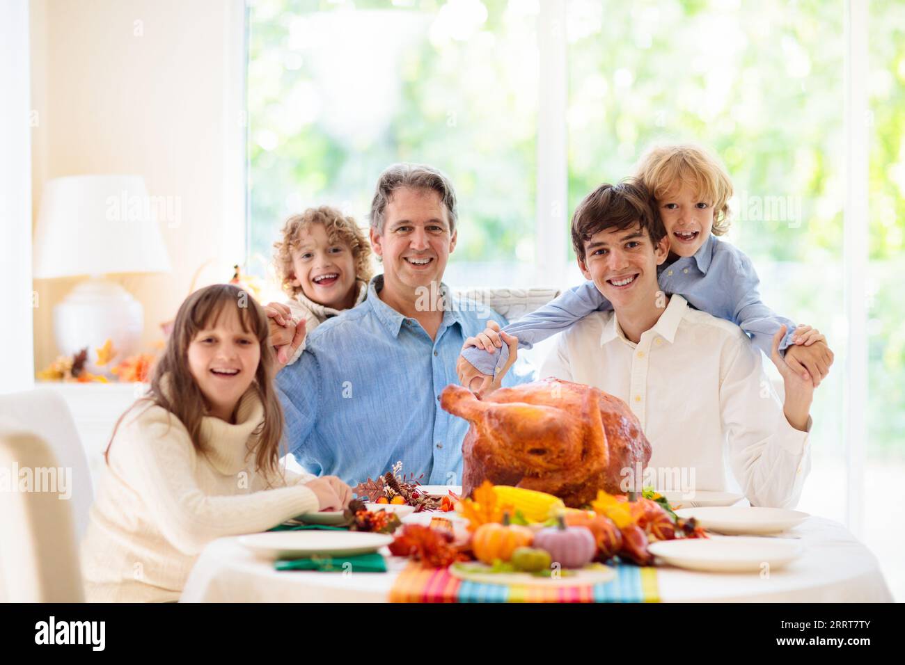 Family at Thanksgiving dinner. Parents and kids enjoy roasted turkey ...