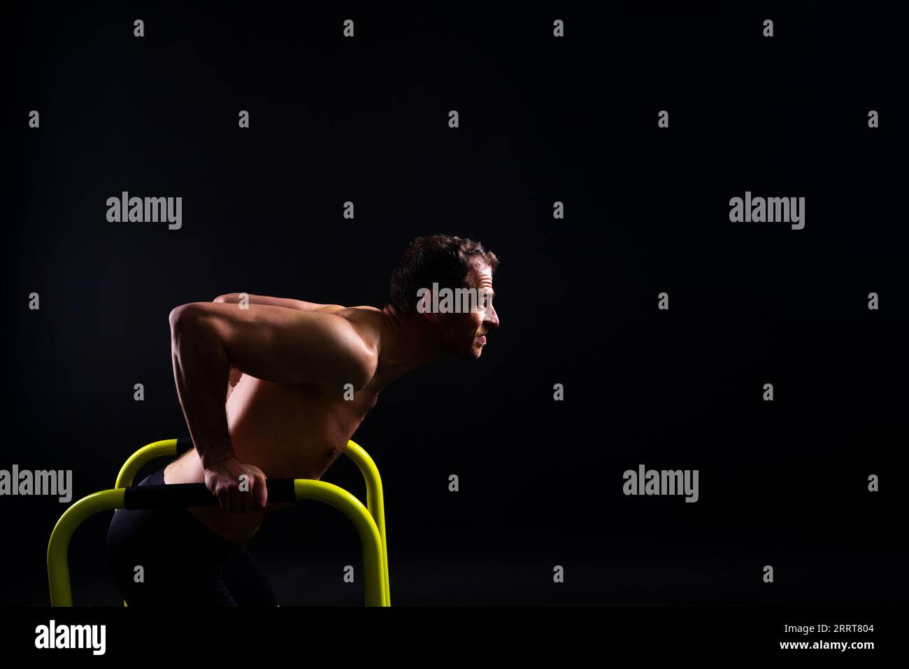 Strong man doing sports. Fitness on gorizontal and parallel bars. Pull ...