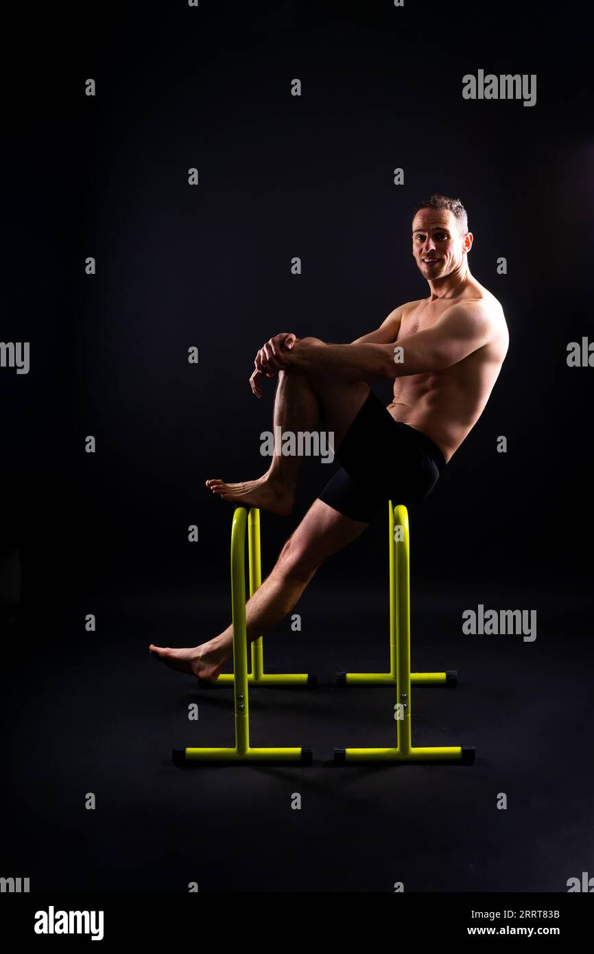 Strong man doing sports. Fitness on gorizontal and parallel bars. Pull ...