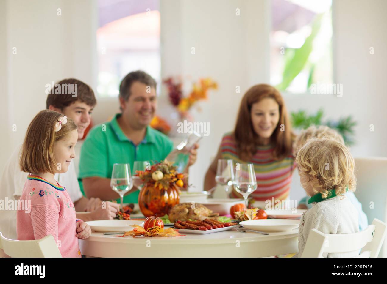 Family with kids eating Thanksgiving dinner. Roasted turkey and pumpkin ...