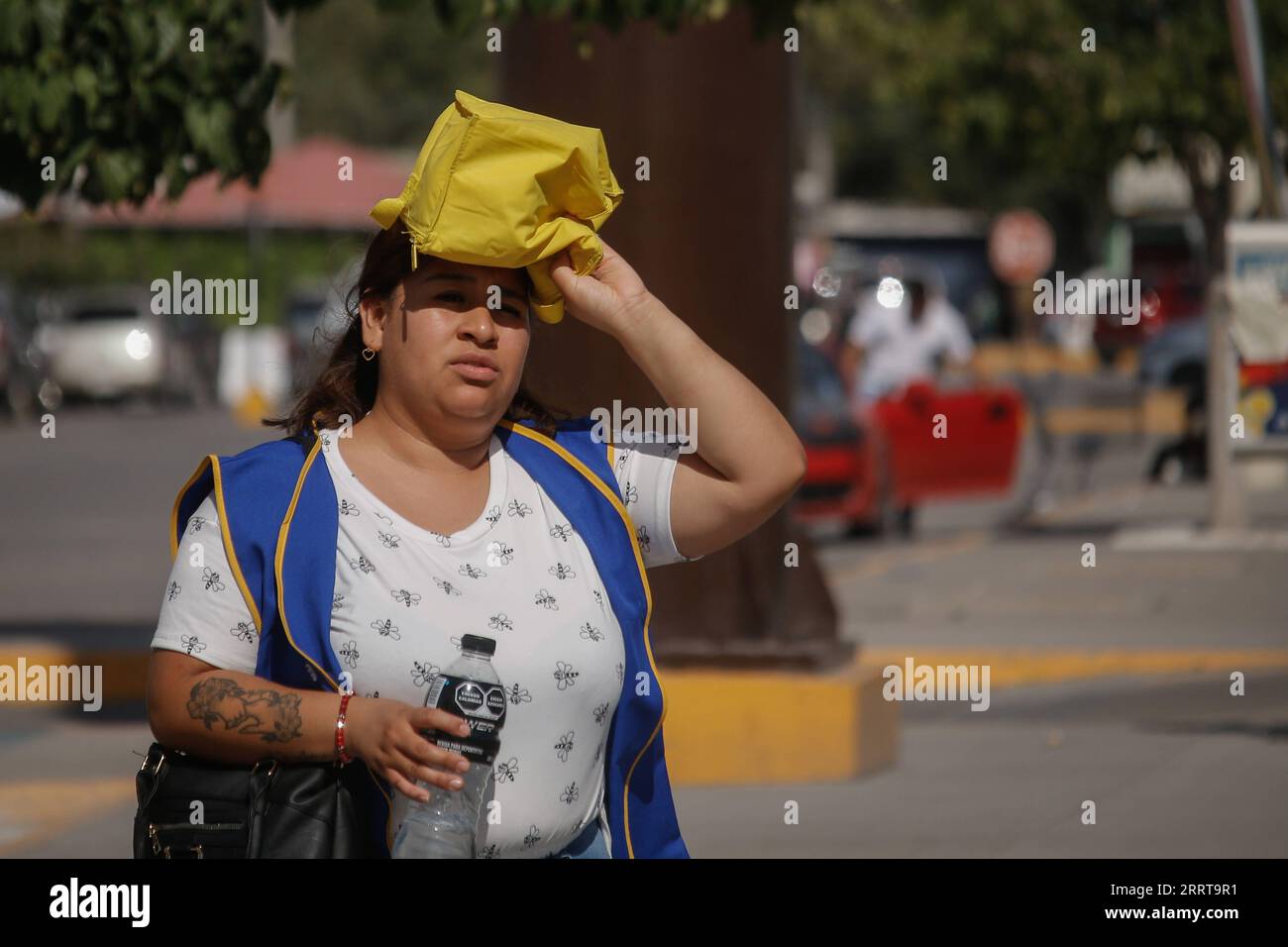 230708 -- CIUDAD JUAREZ, July 8, 2023 -- A woman protects herself from ...