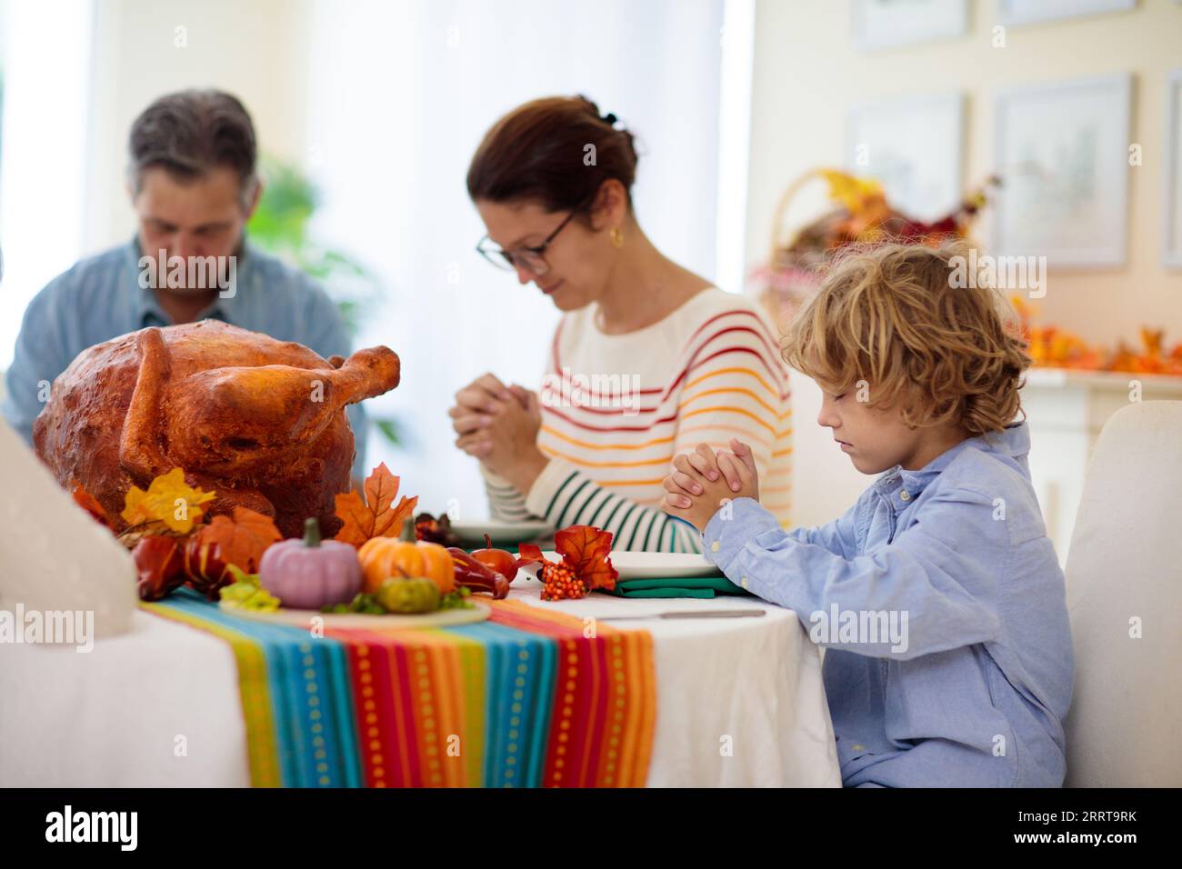 Family Thanksgiving dinner prayer. Parents and kids enjoy roasted ...