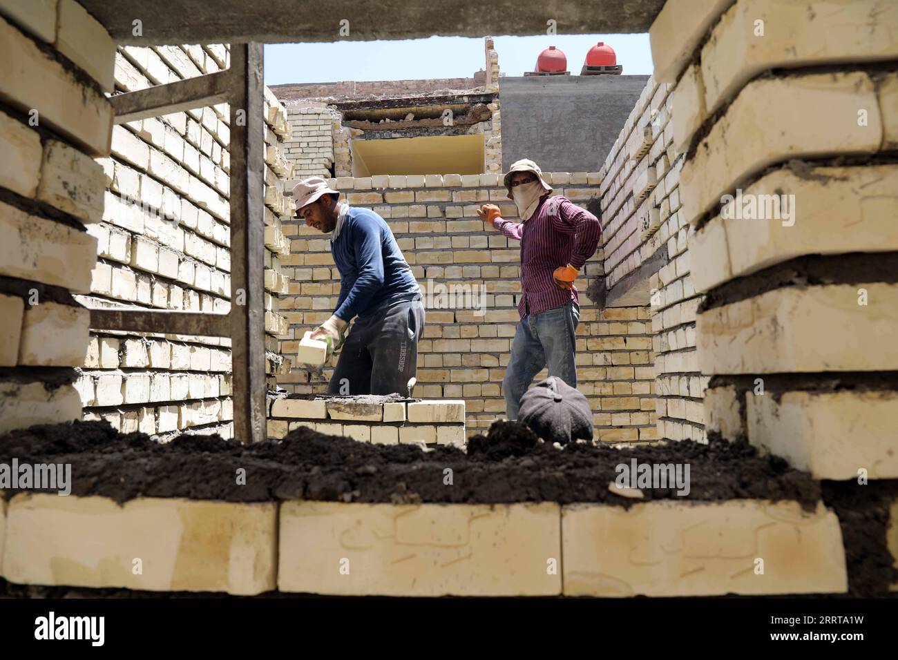 230708 -- BAGHDAD, July 8, 2023 -- Construction workers work in hot ...