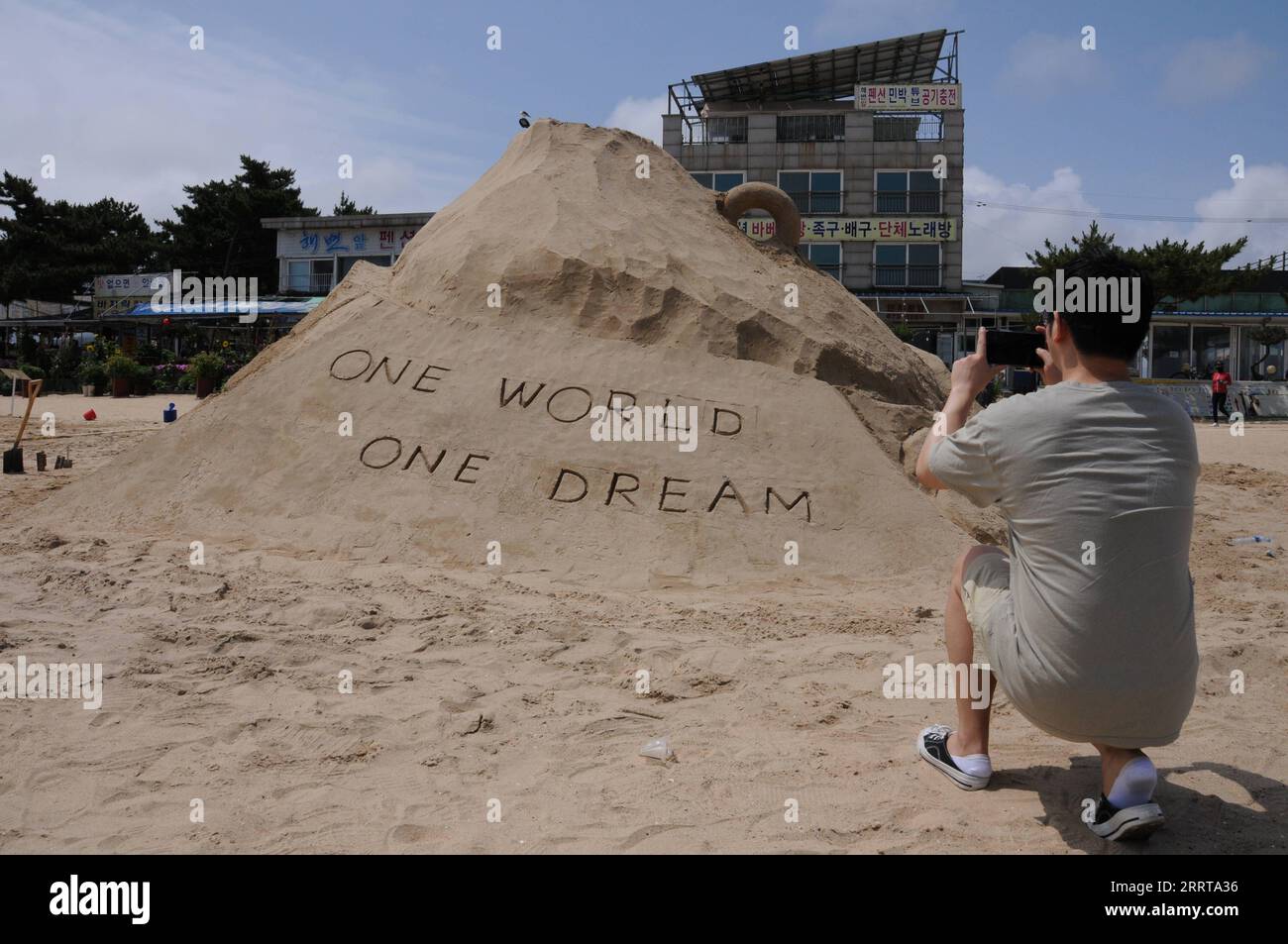 230708 -- TAEAN, July 8, 2023 -- A man takes pictures of a sand ...