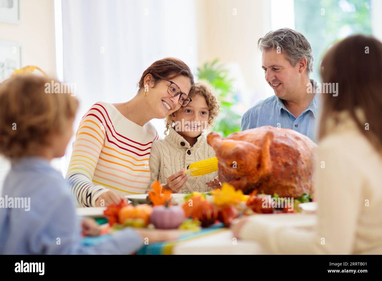 Family at Thanksgiving dinner. Parents and kids enjoy roasted turkey ...