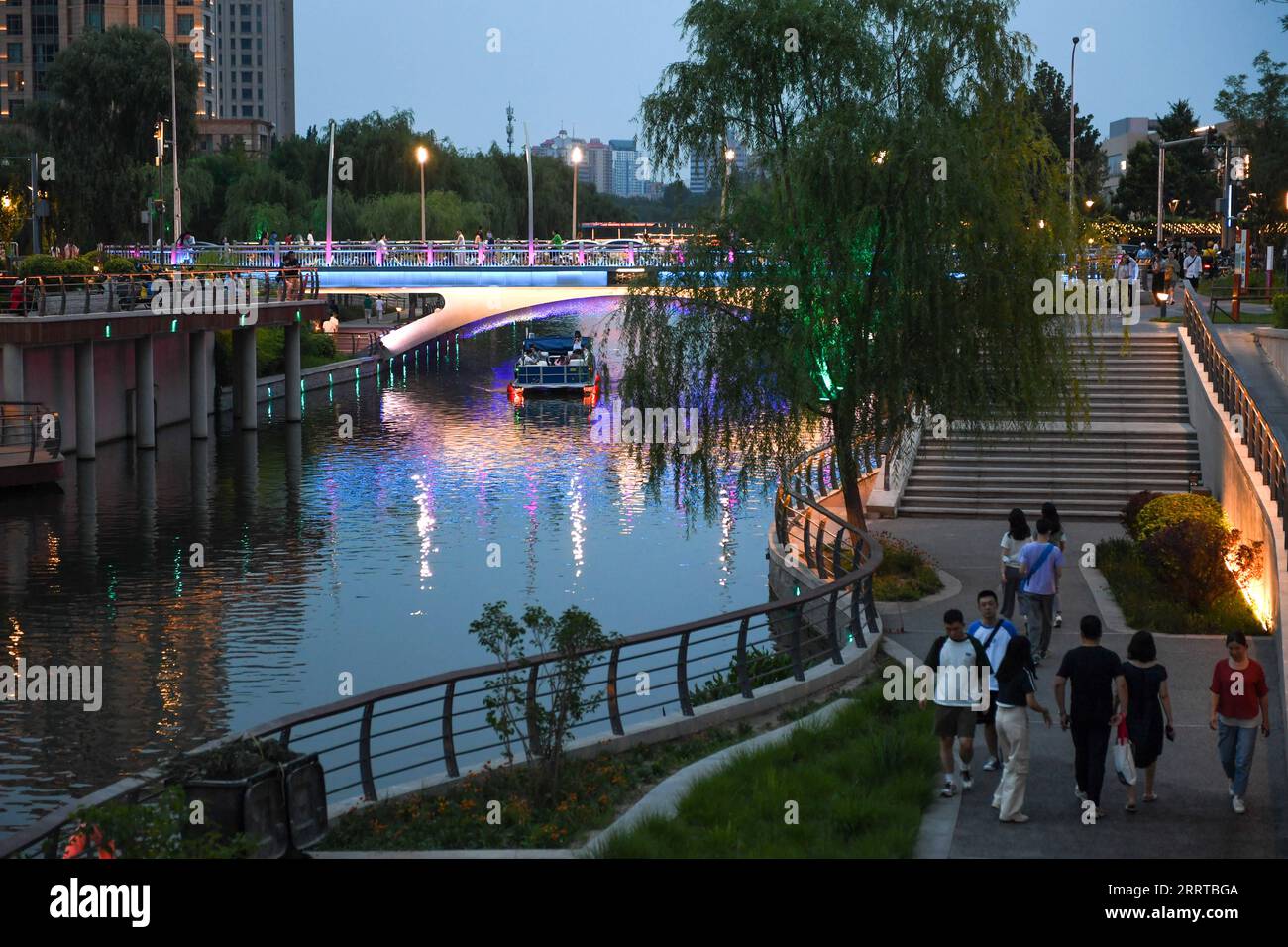 230713 -- BEIJING, July 13, 2023 -- People take a walk along the ...