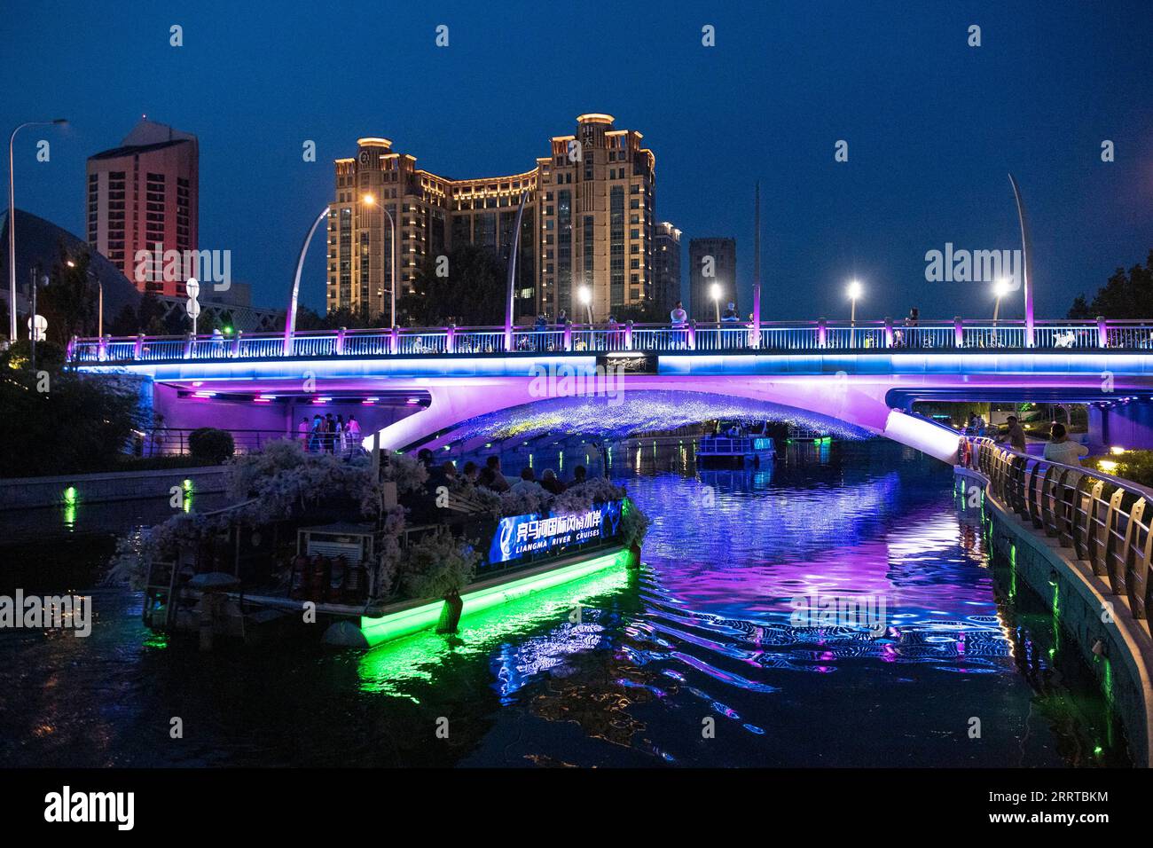 230713 -- BEIJING, July 13, 2023 -- Tourists take an evening boat tour ...