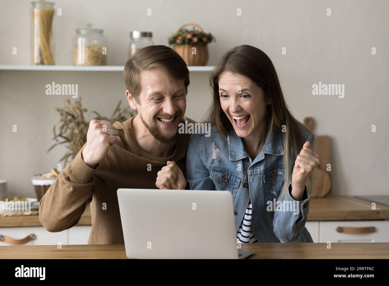 Happy shouting millennial couple celebrating win, victory Stock Photo ...