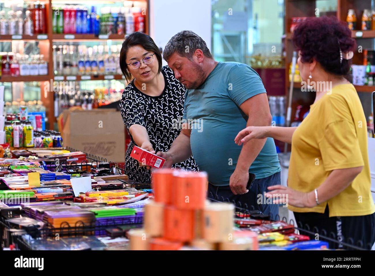 230723 -- TACHENG, July 23, 2023 -- Tourists select commodities at a ...