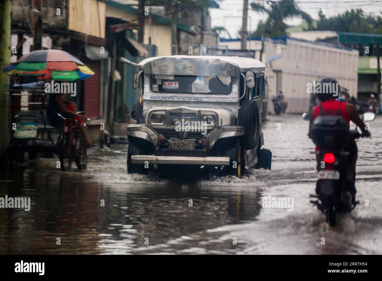 230726 -- MALABON CITY, July 26, 2023 -- A jeepney drives through a ...