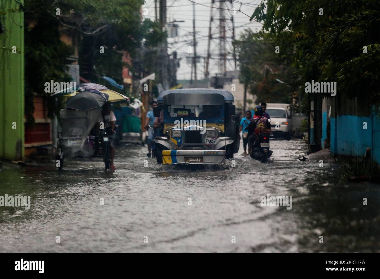 230726 -- MALABON CITY, July 26, 2023 -- People wade through a water ...