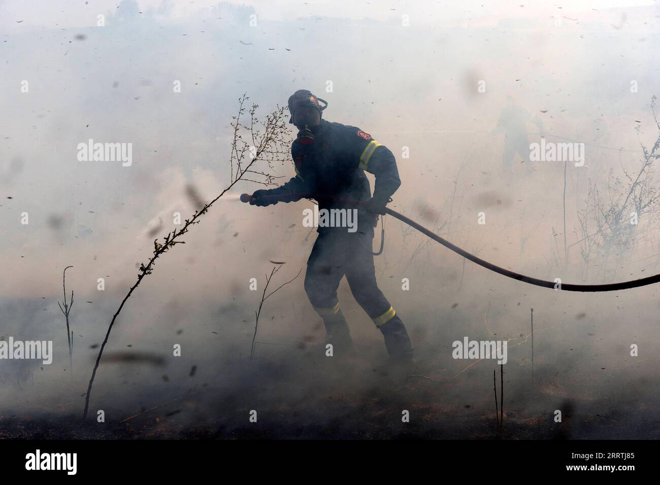 230727 -- VOLOS, July 27, 2023 -- A firefighter tries to put out a ...