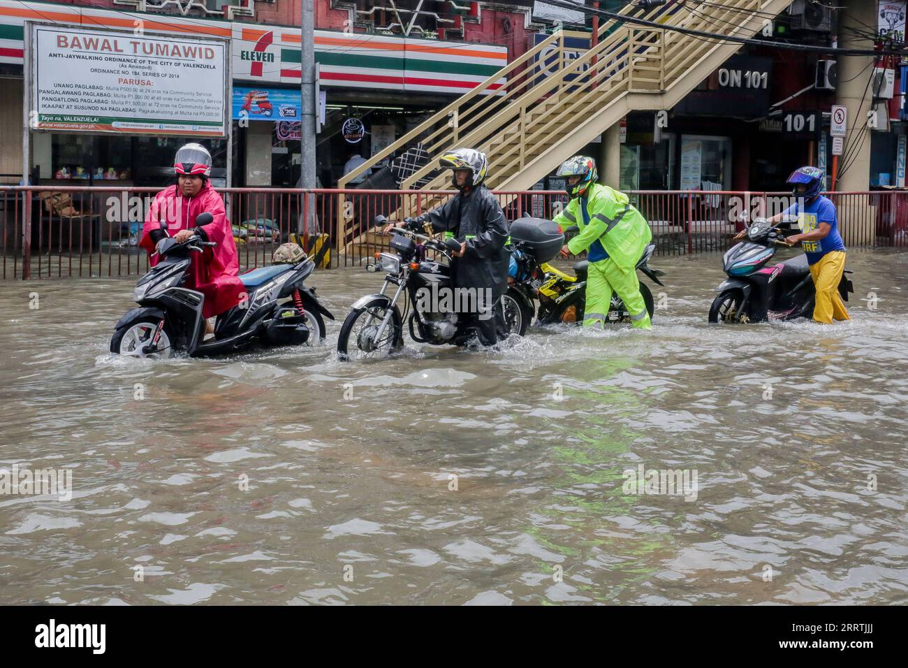 230728 -- VALENZUELA CITY, July 28, 2023 -- People push their ...