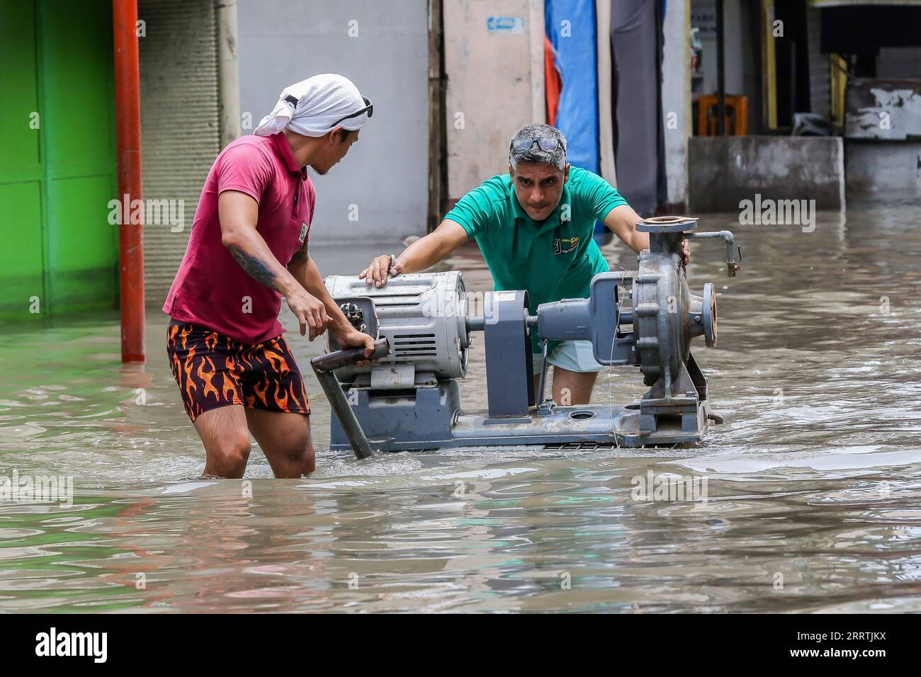 230728 -- VALENZUELA CITY, July 28, 2023 -- People wade through ...