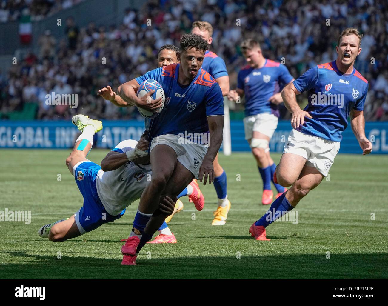 Namibia's Gerswin Mouton is tackled by Italy's Ange Capuozzo, left, during the Rugby World Cup ...