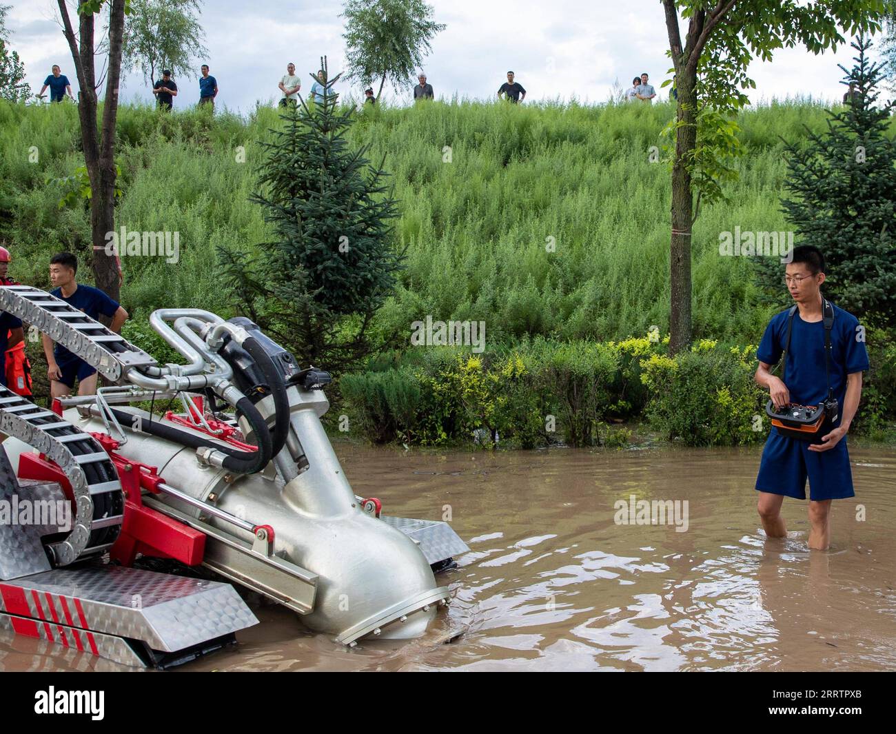 230805 -- HARBIN, Aug. 5, 2023 -- Firefighters operate a drainage ...