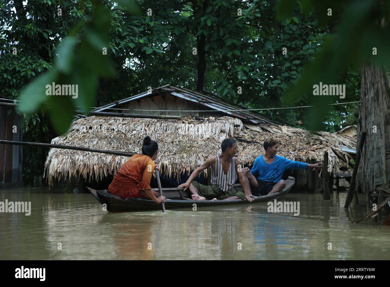 230812 -- BAGO, Aug. 12, 2023 -- People row a wooden boat on flood ...