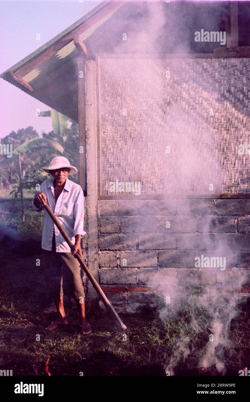 Local Balinese farmer burning trash outside in the field causing air ...